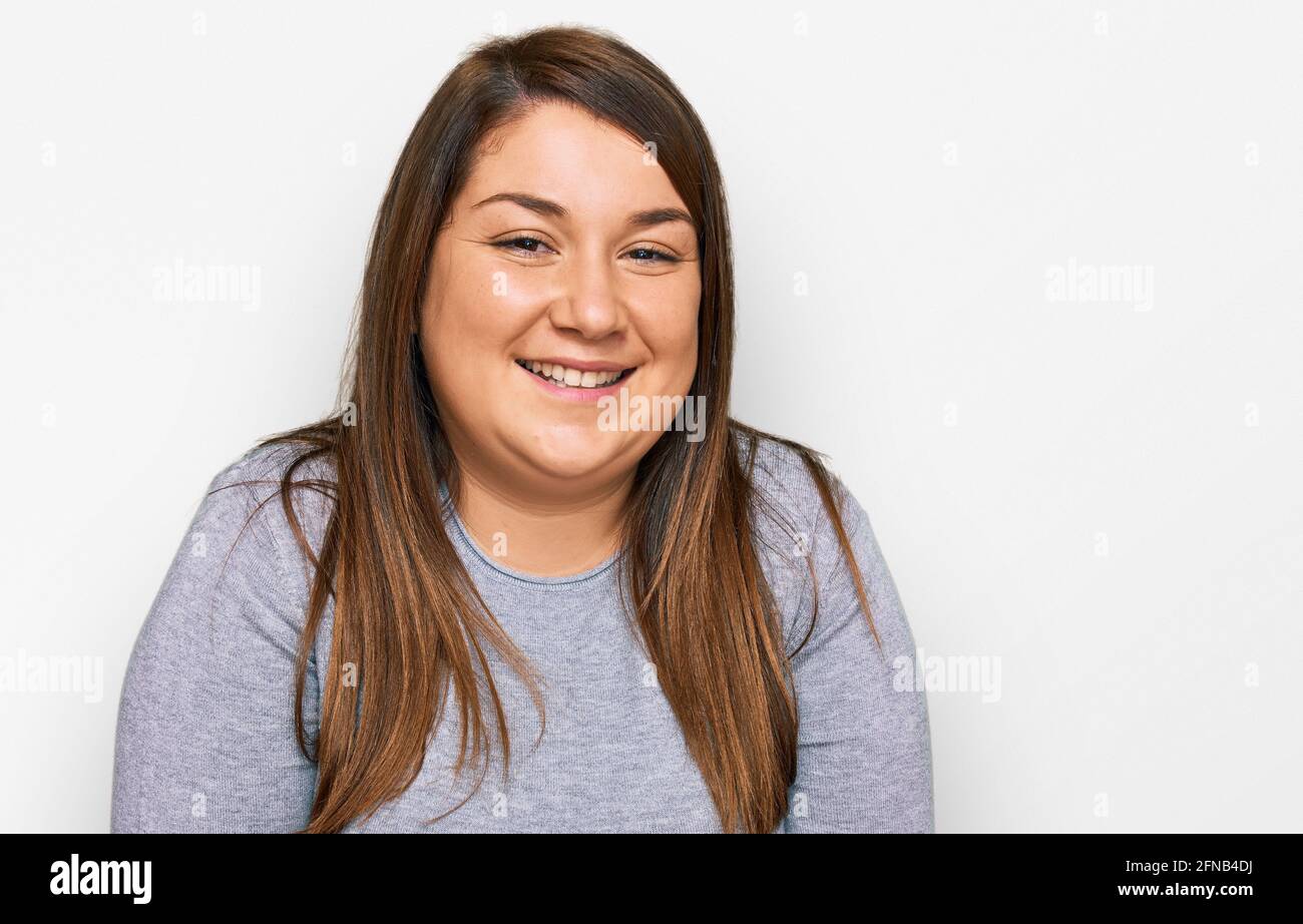 Beautiful brunette plus size woman wearing casual clothes smiling and ...