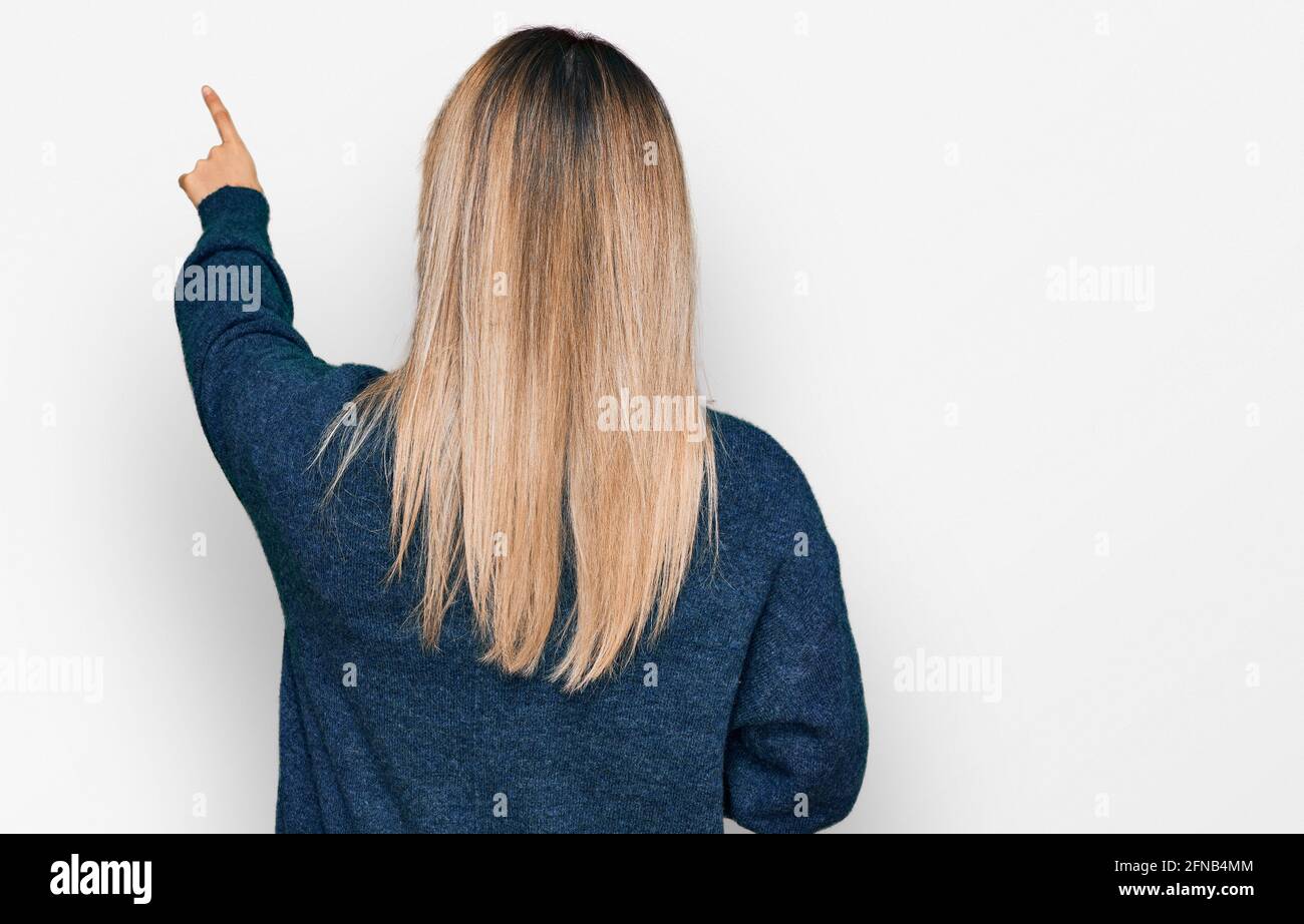 Young caucasian woman wearing casual clothes posing backwards pointing ...