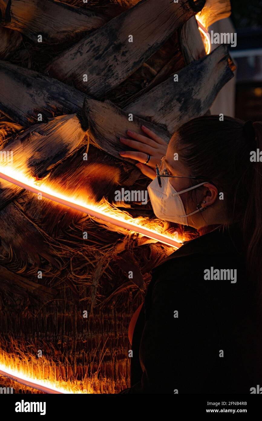 Beautiful girl lit by the leds of a palm tree Stock Photo - Alamy