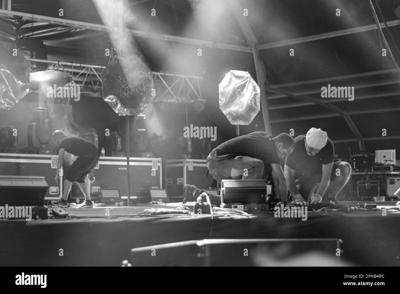 Roadies or riggers working on stage preparing the next show ir ...