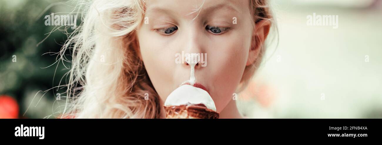 Cute funny adorable girl with dirty nose eating licking ice cream. Kid ...