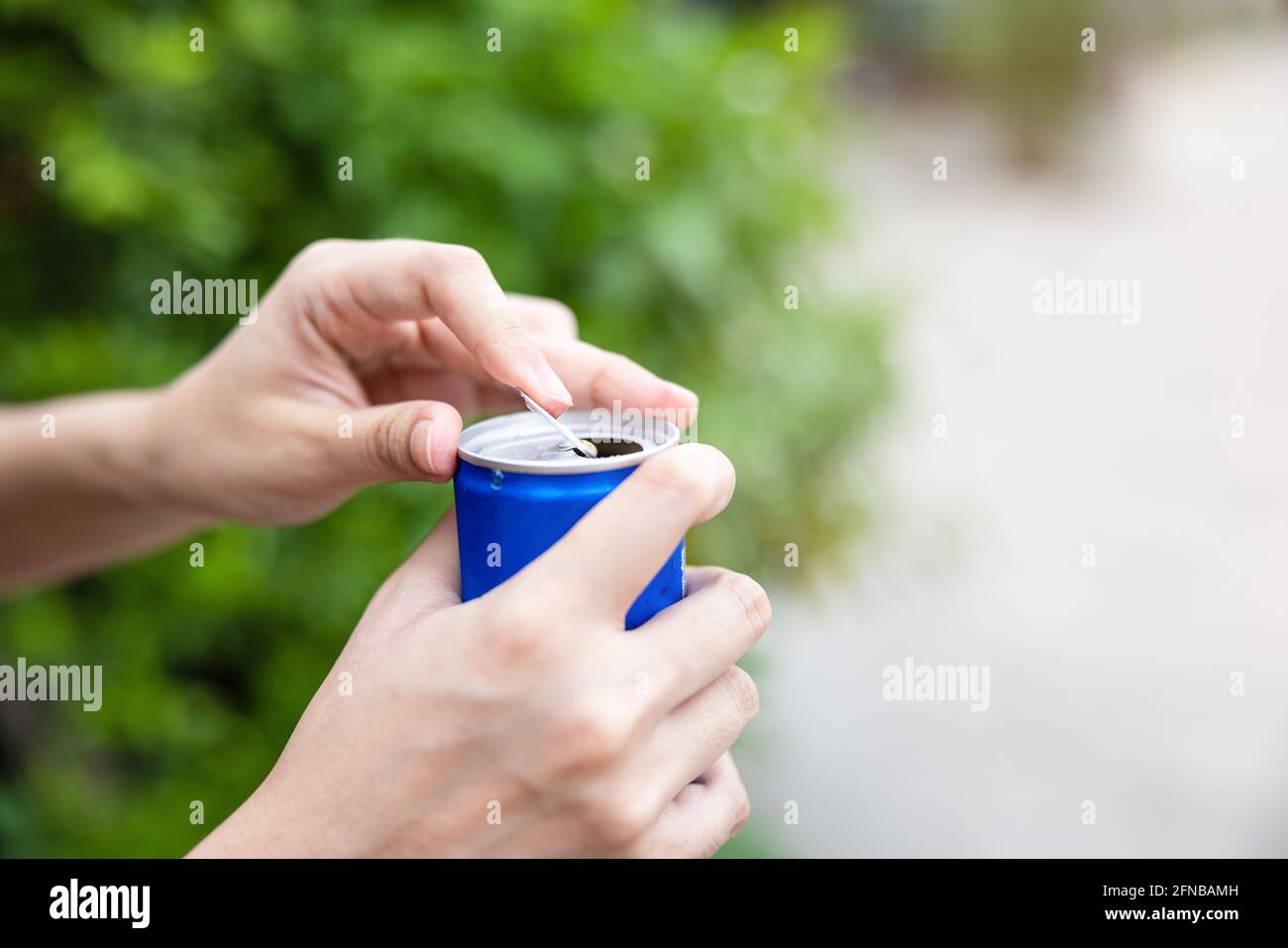 Closeup woman hand open cola can with nature background Stock Photo - Alamy