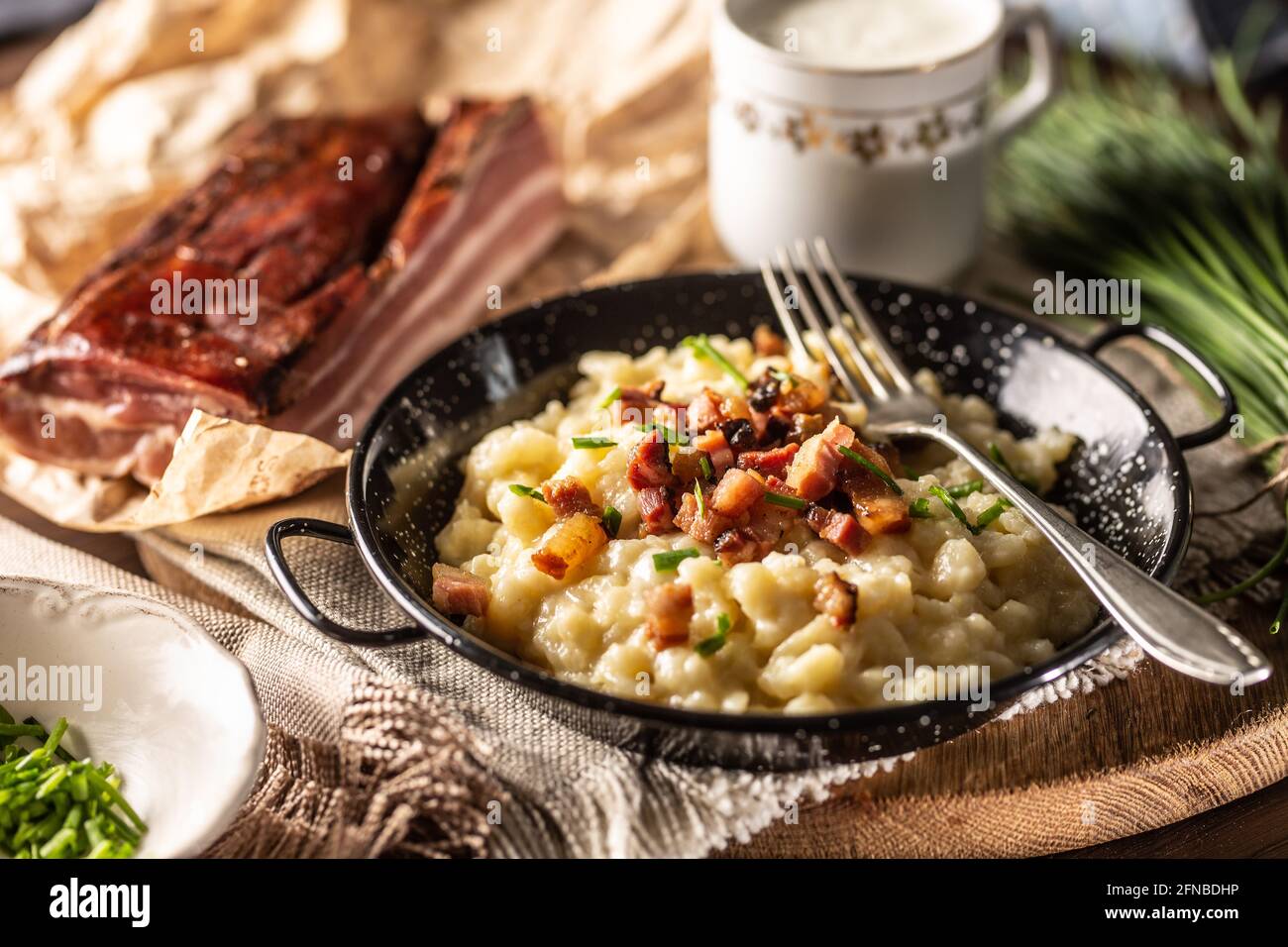 Slovak national dish bryndzove halushky served next to bacon and a gcup ...