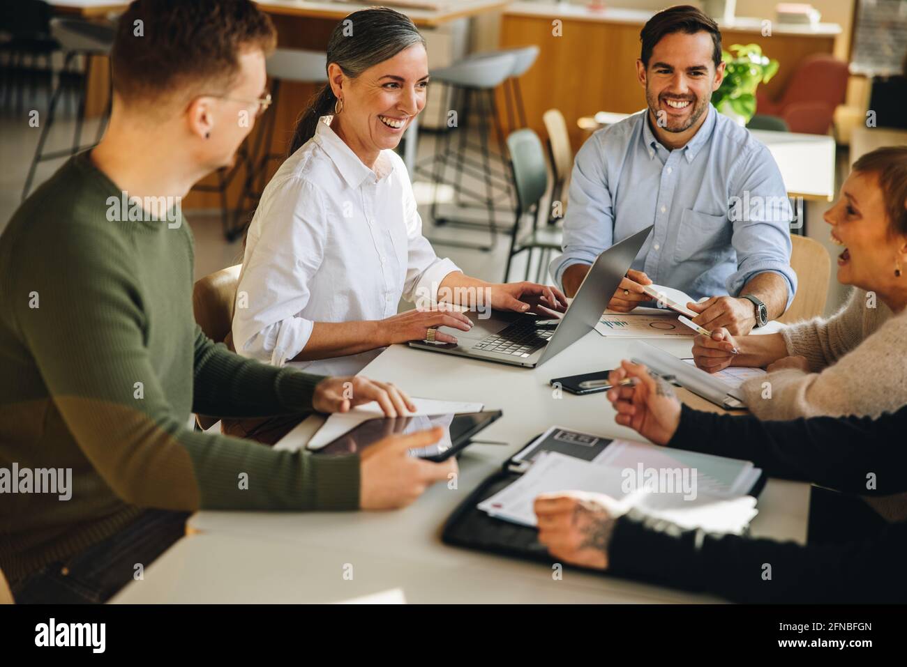 Creative team sitting around table discussing new project. business ...