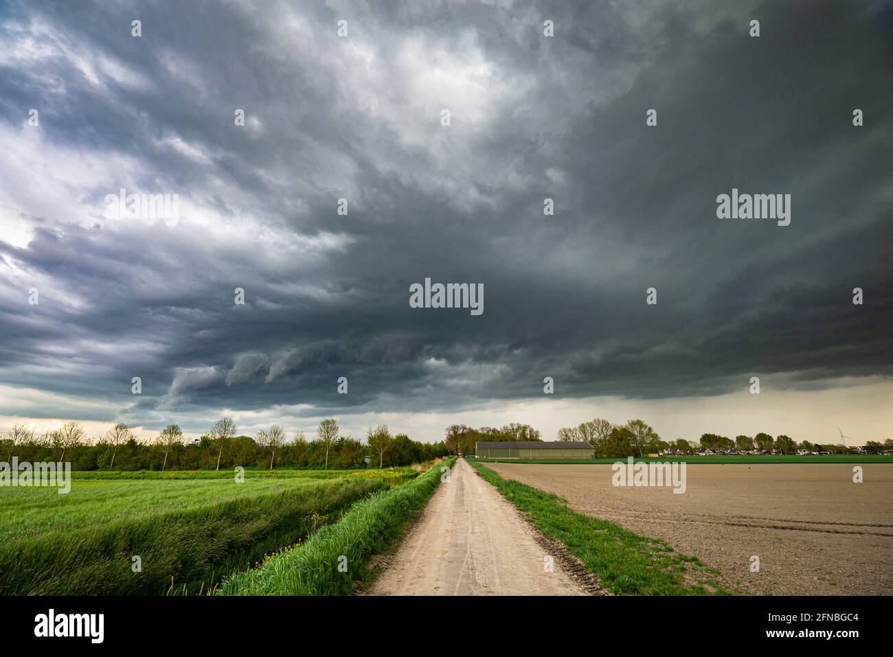 Dramatic looking thundercloud over a country road Stock Photo - Alamy