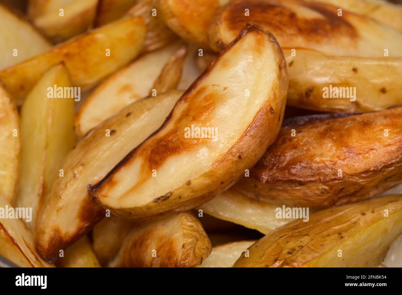 Oven made potato wedge chips comfort food background Stock Photo - Alamy