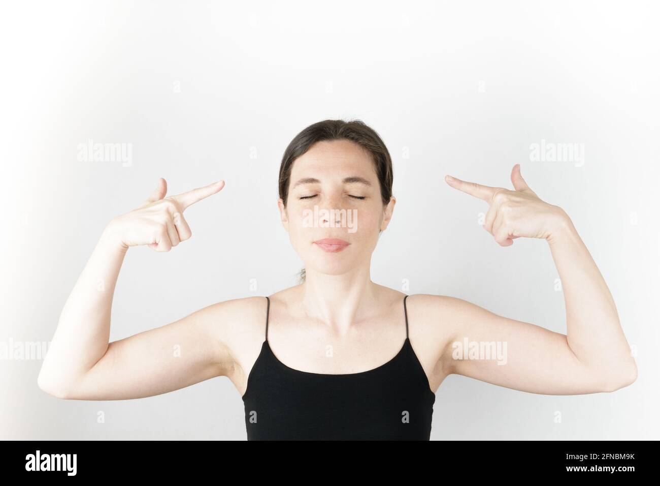 Young beautiful woman pointing up with fingers while thinking at white ...