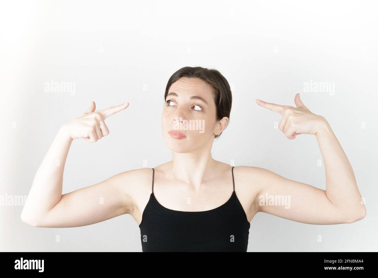 Young beautiful woman pointing up with fingers while thinking at white ...