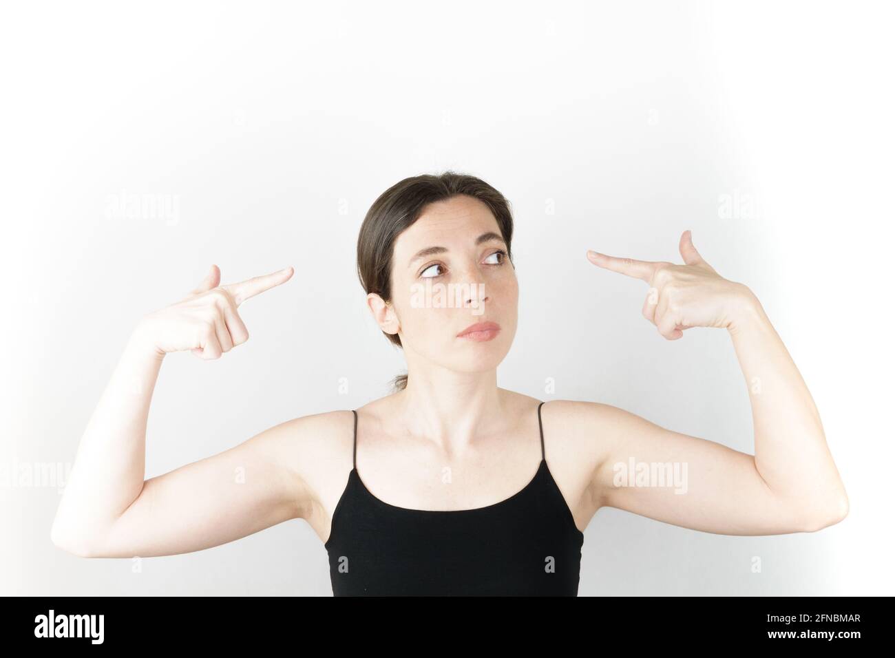 Young beautiful woman pointing up with fingers while thinking at white ...
