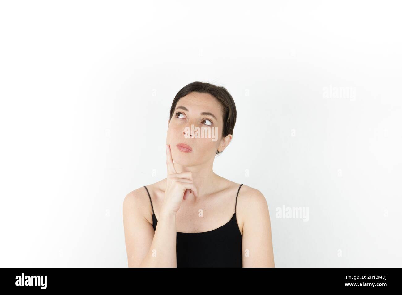 Young beautiful woman pointing up with fingers while thinking at white ...