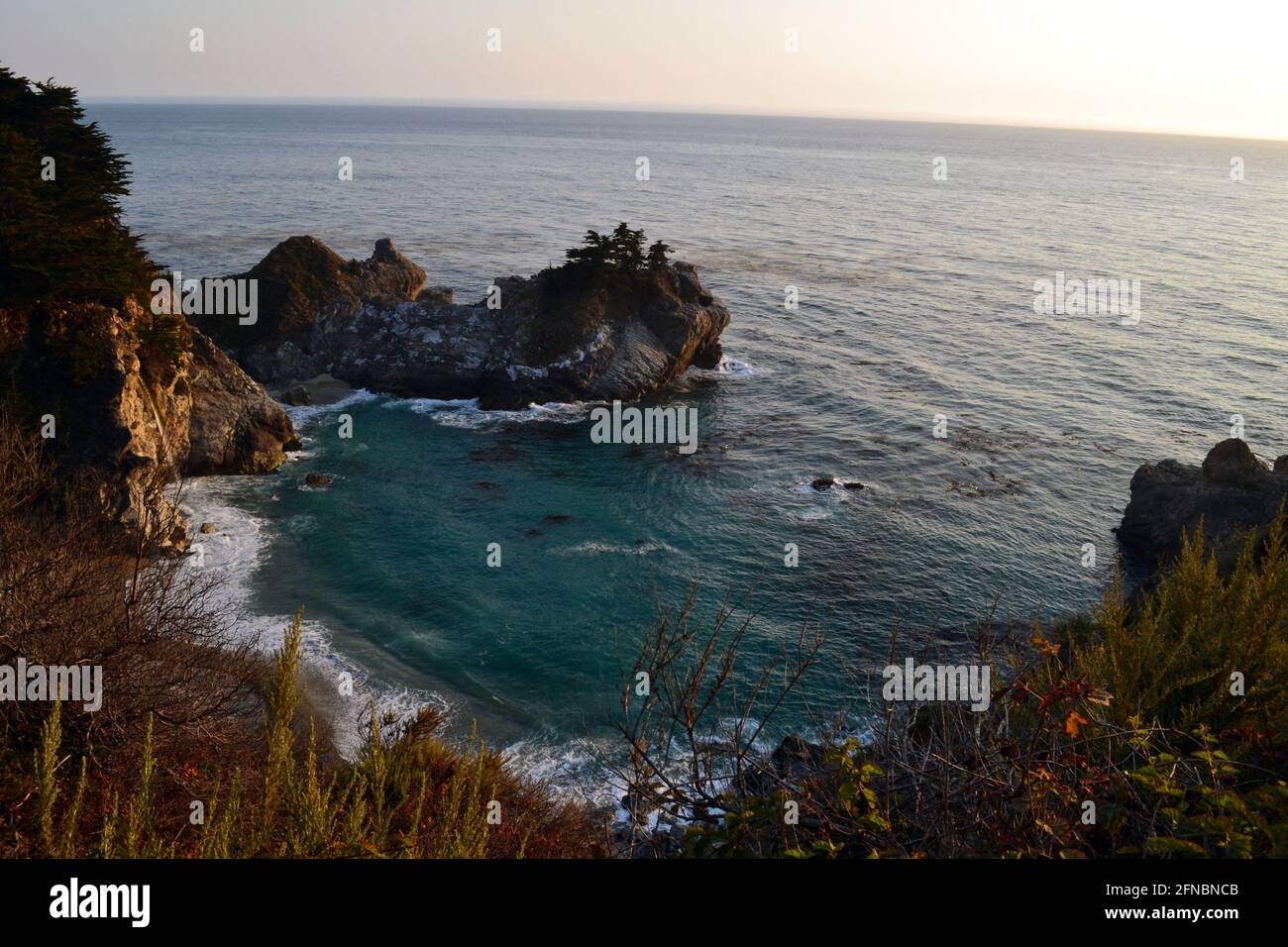A scenic view of a waterfall at the coast of the Pacific Ocean in the ...
