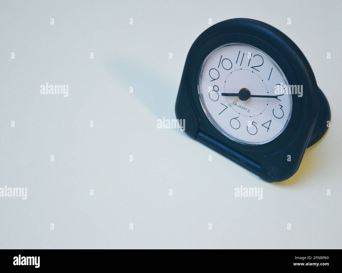 Photo of a clock on light blue background Stock Photo - Alamy