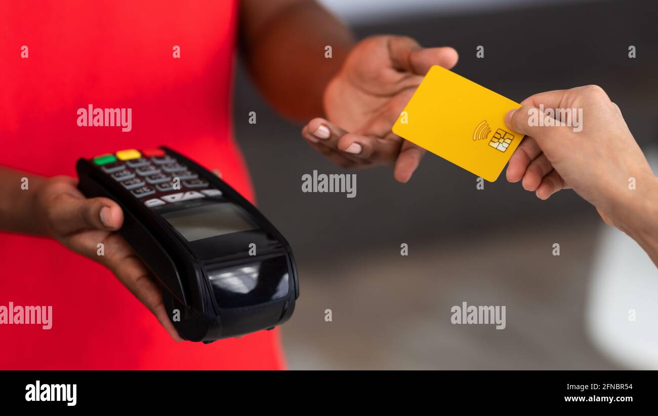 Closeup of black delivery man in uniform holding POS machine Stock ...