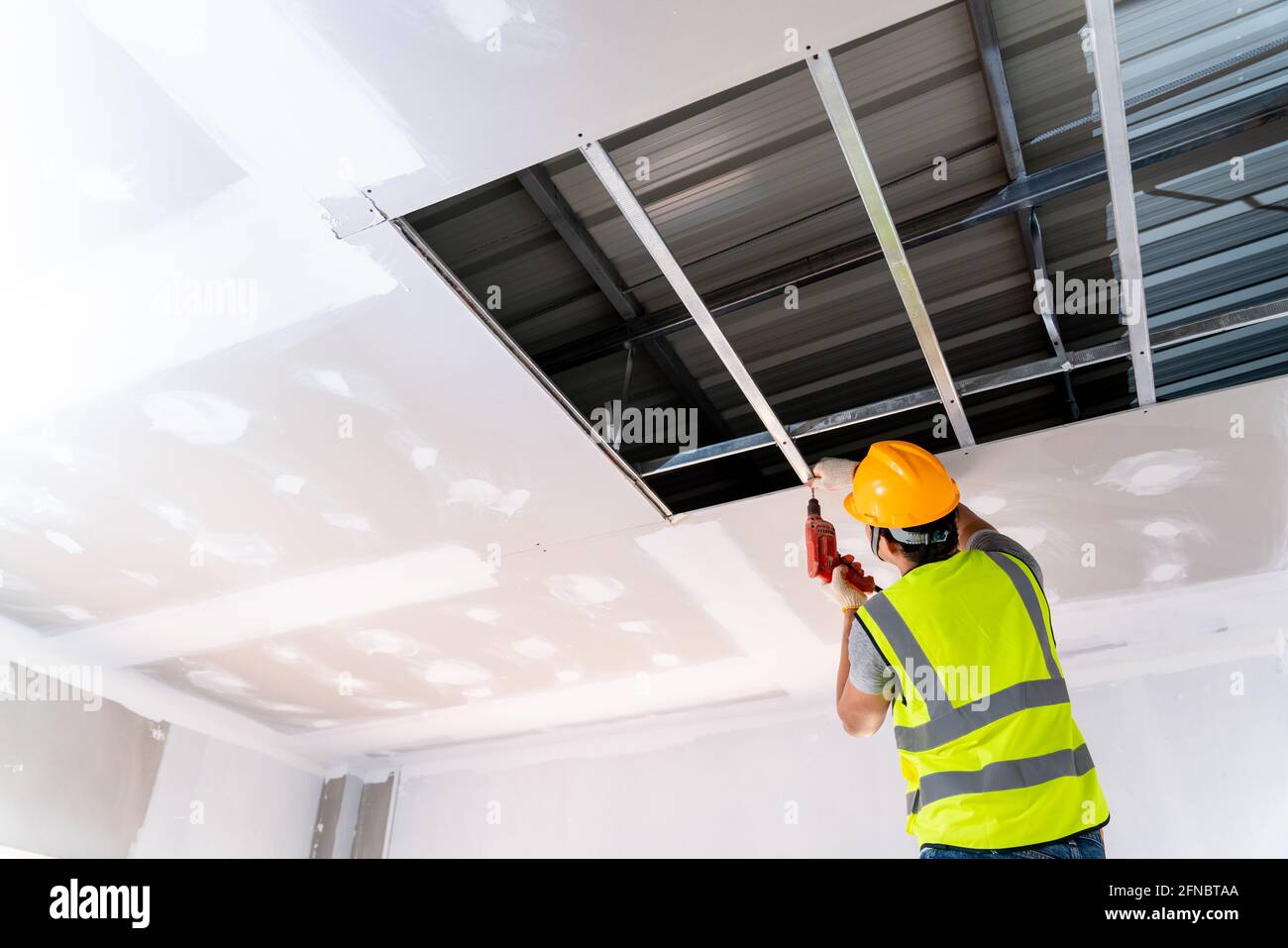 Construction workers are installing the ceiling house in the building ...
