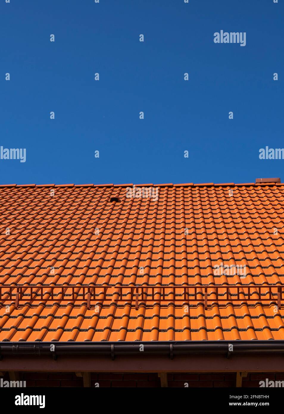 Red corrugated metal profile roof installed on a modern house. The roof ...