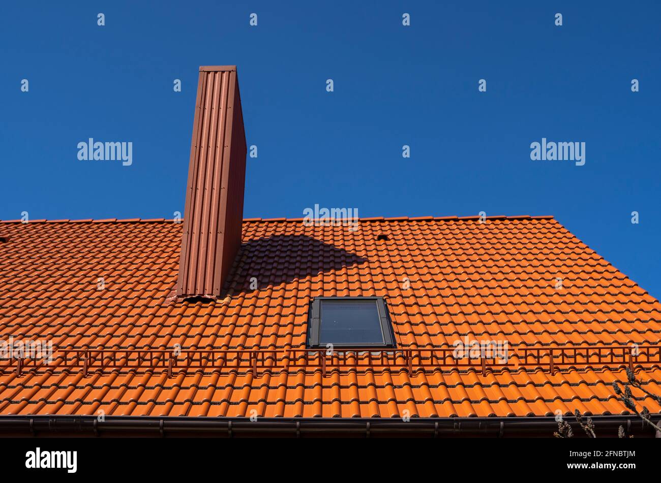 Red corrugated metal profile roof installed on a modern house. The roof ...