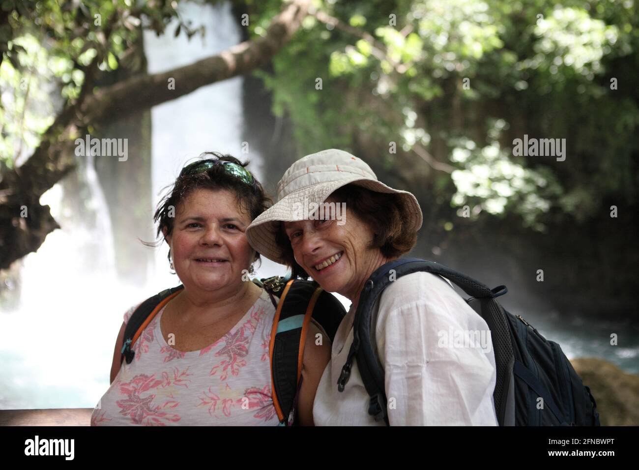 Senior women in their 60s smile to the camera in the forest with a ...