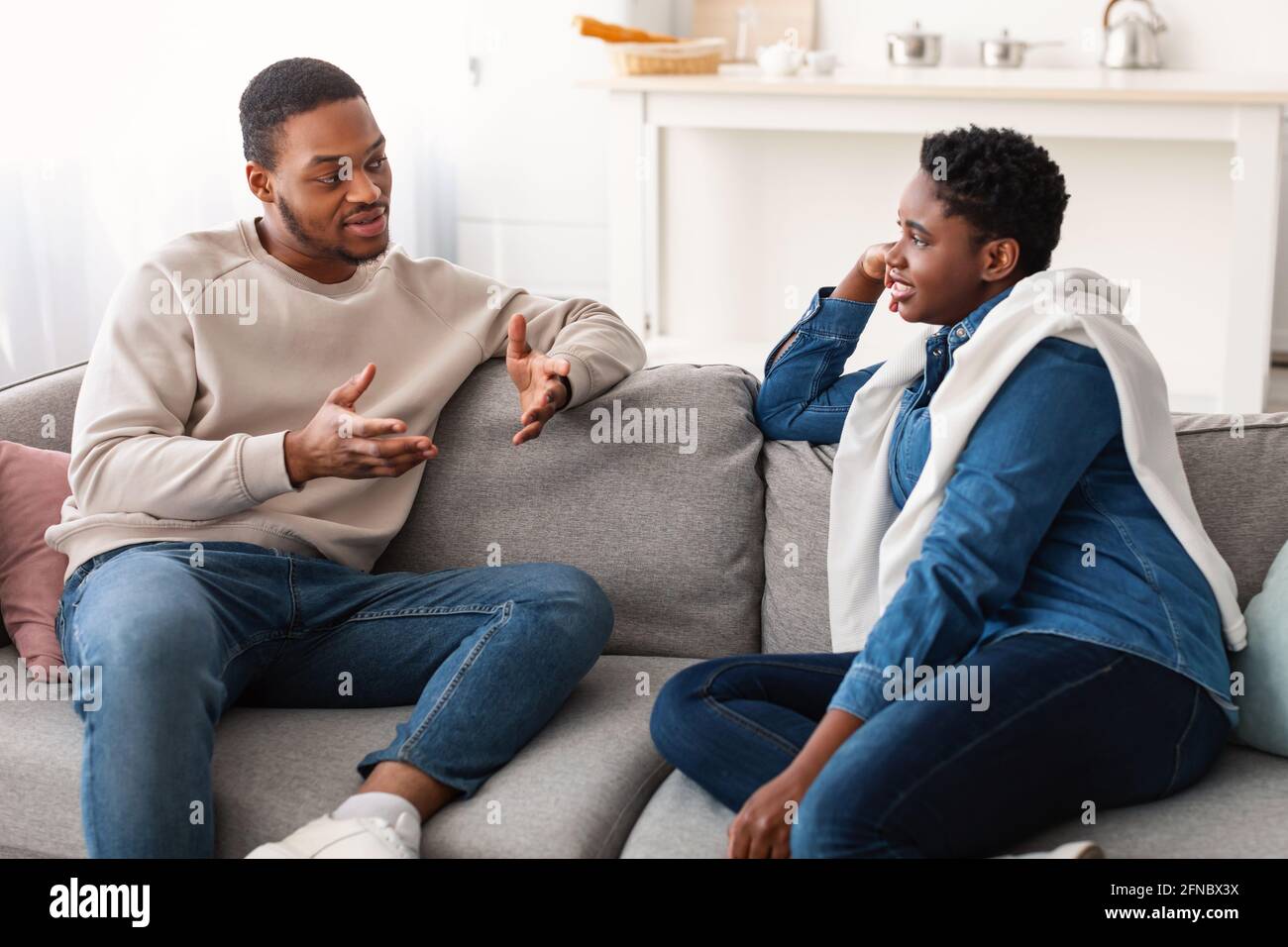 Black couple talking and spending time together sitting on couch Stock ...