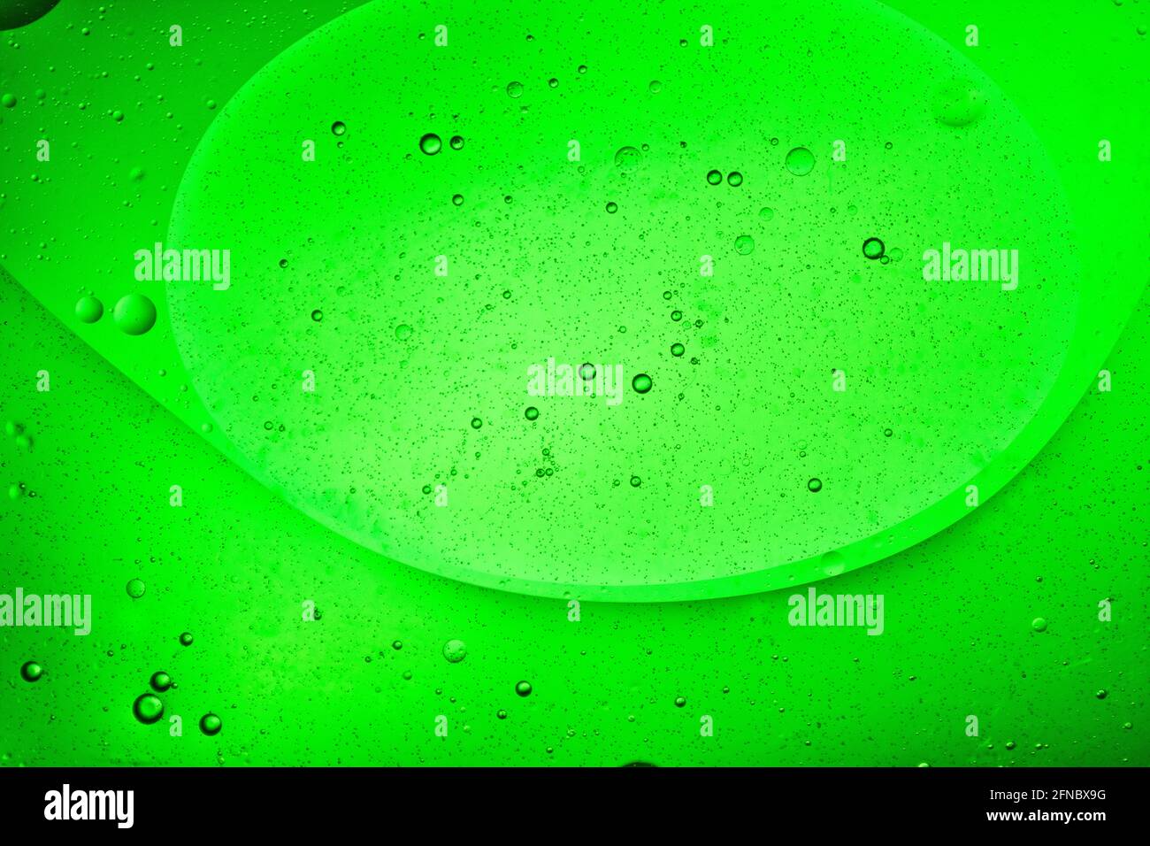 close-up view of a bright green liquid background of moving bubbles ...
