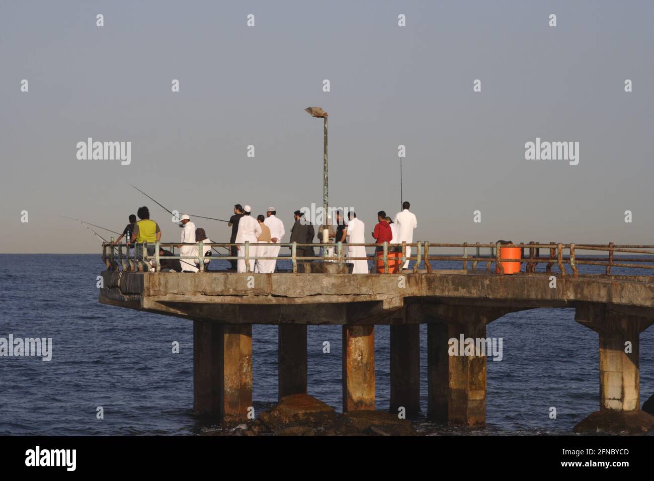 Group of men fishing from a jetty, Jeddah, Kingdom of Saudi Arabia ...
