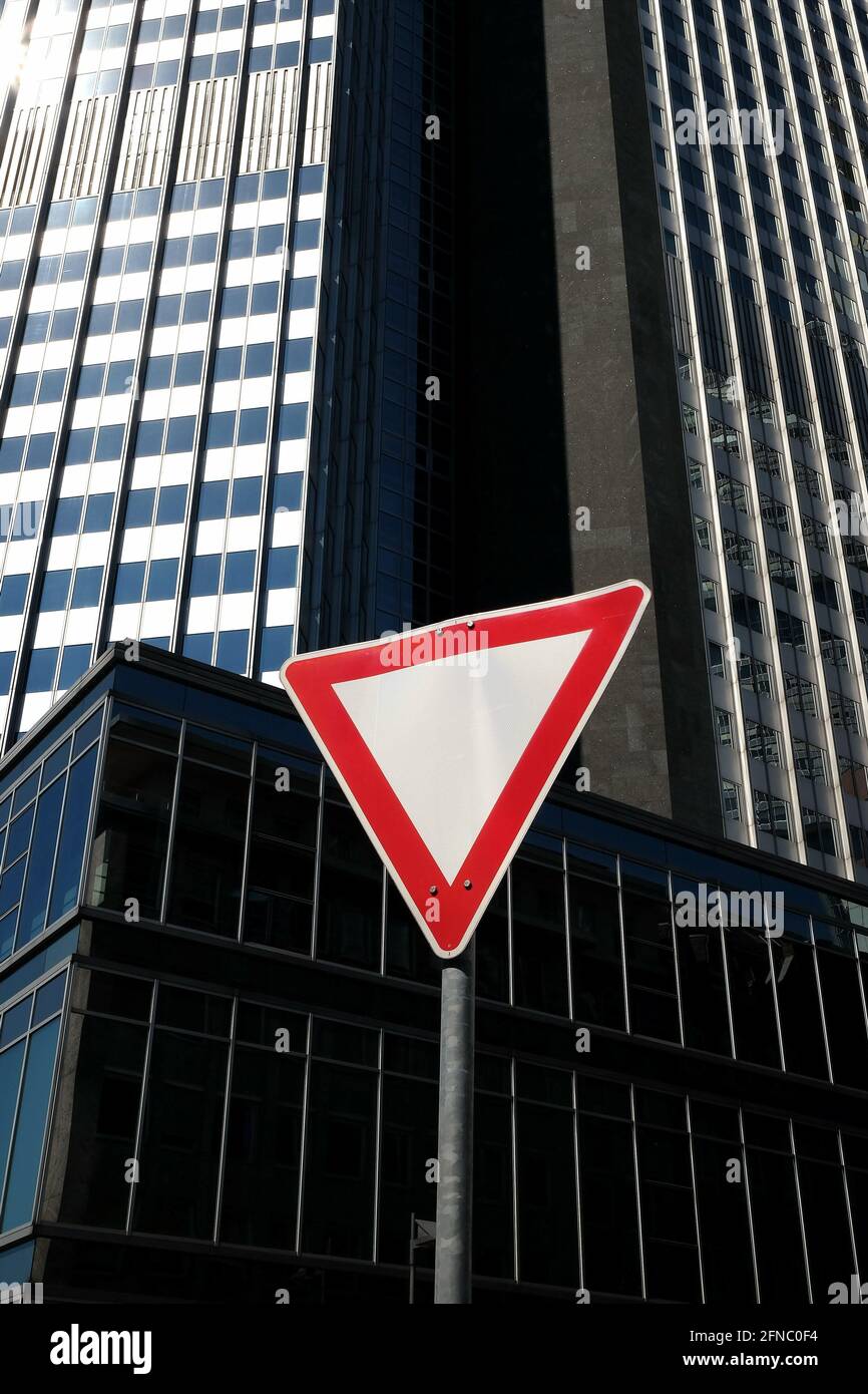 An international traffic sign 'Give way' in the background of modern ...