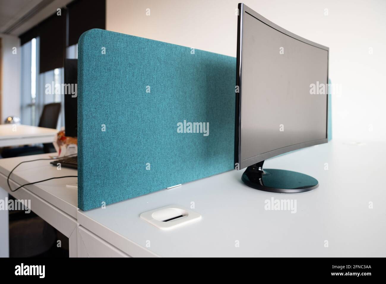 Barrier placed between two office desks in preparation of people coming ...