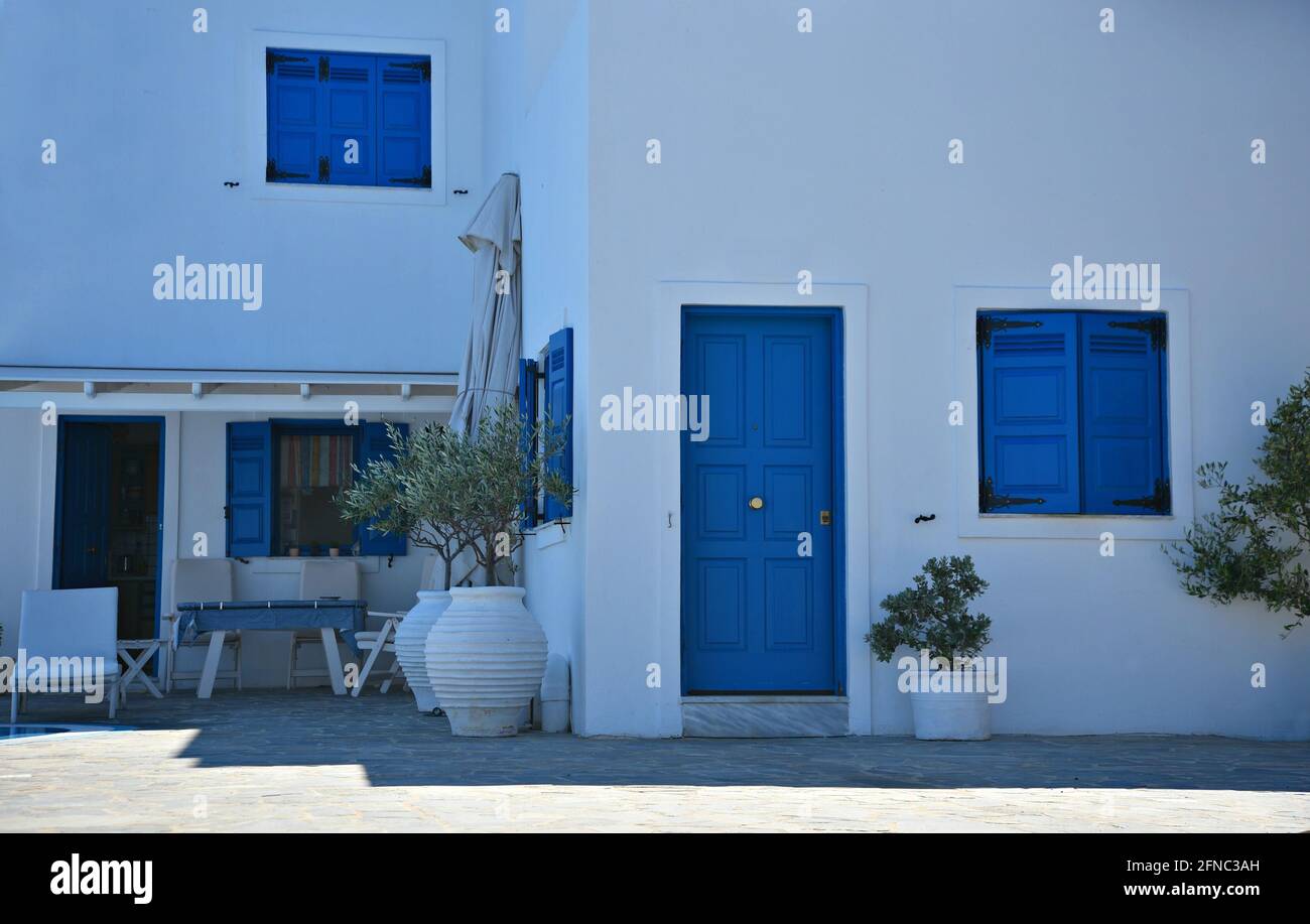 Traditional Cycladic architecture whitewashed house facade with blue ...