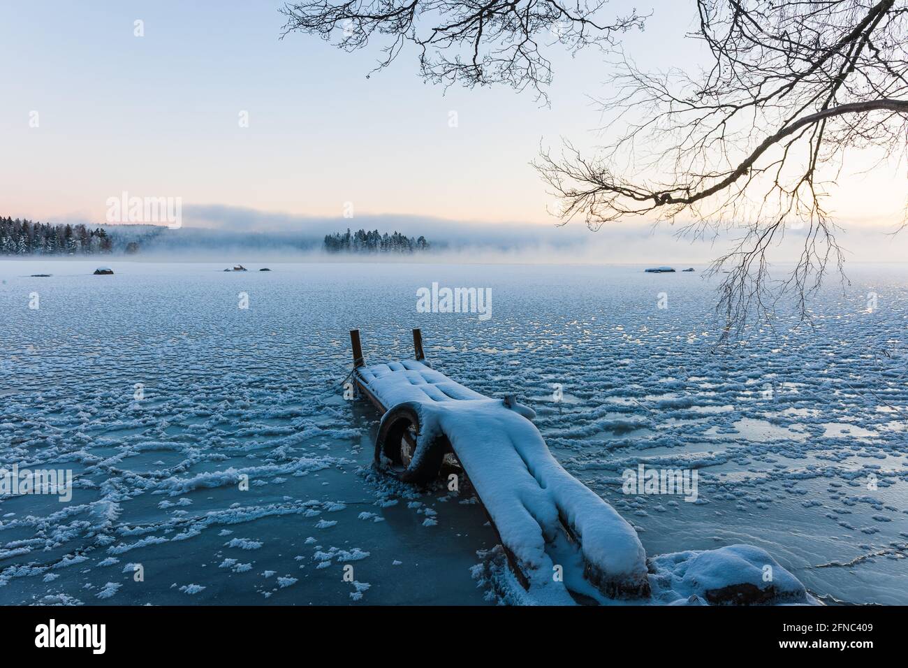 Snow covered jetty on frozen lake Stock Photo - Alamy