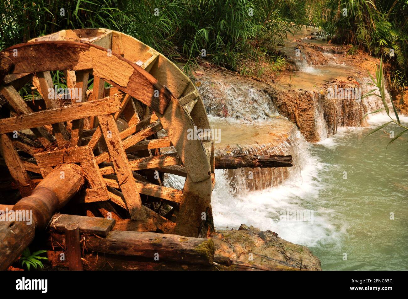 Wooden water turbine at outdoor in forest of Tat Kuang Si Waterfalls or ...