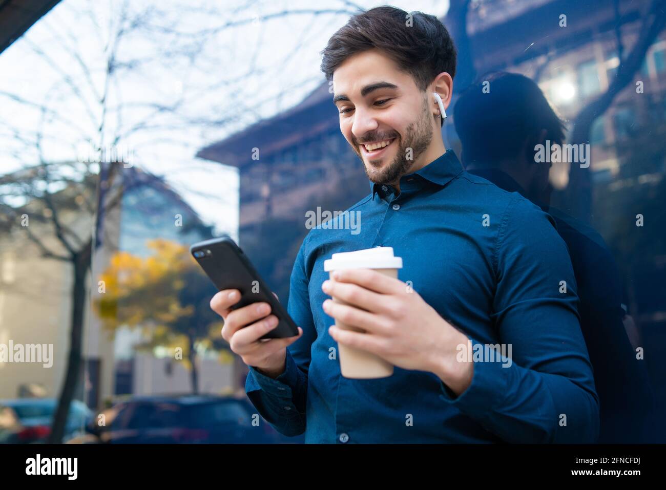 Young man using his mobile phone outdoors Stock Photo - Alamy