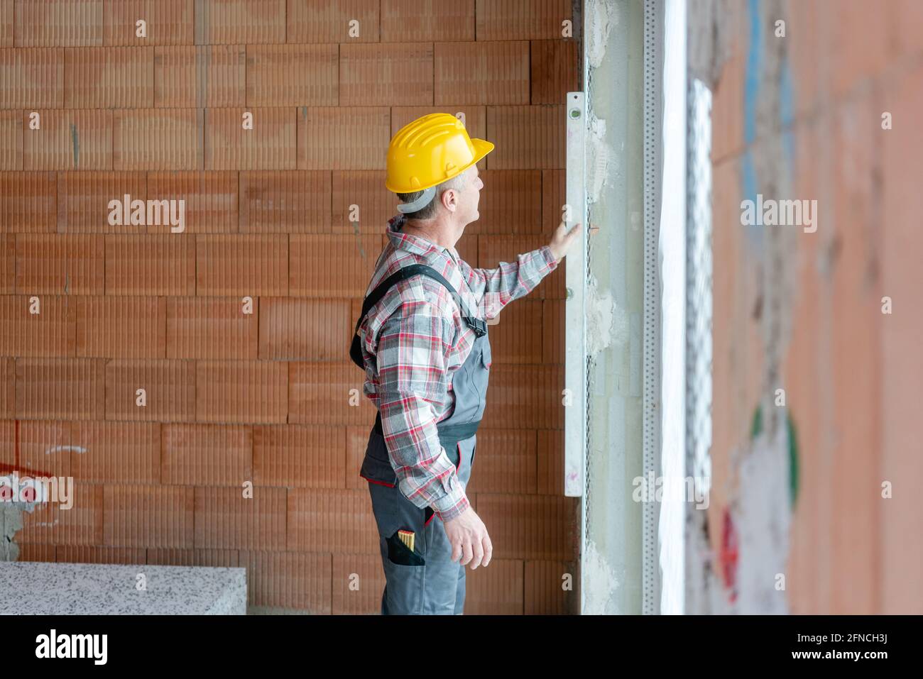Senior male construction worker measuring the wall Stock Photo - Alamy