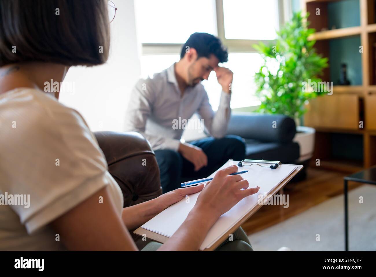 Psychologist taking notes during therapy session Stock Photo - Alamy