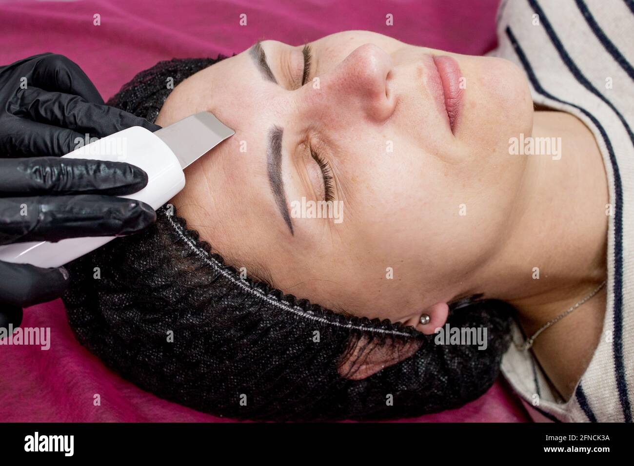 Cosmetologist,beautician making facial treatment with ultrasonic ...