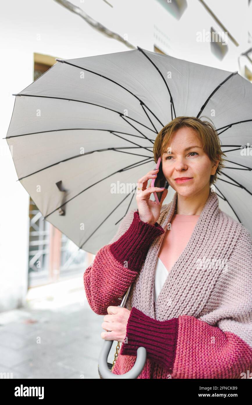 vertical portrait of an attractive caucasian woman talking by phone ...