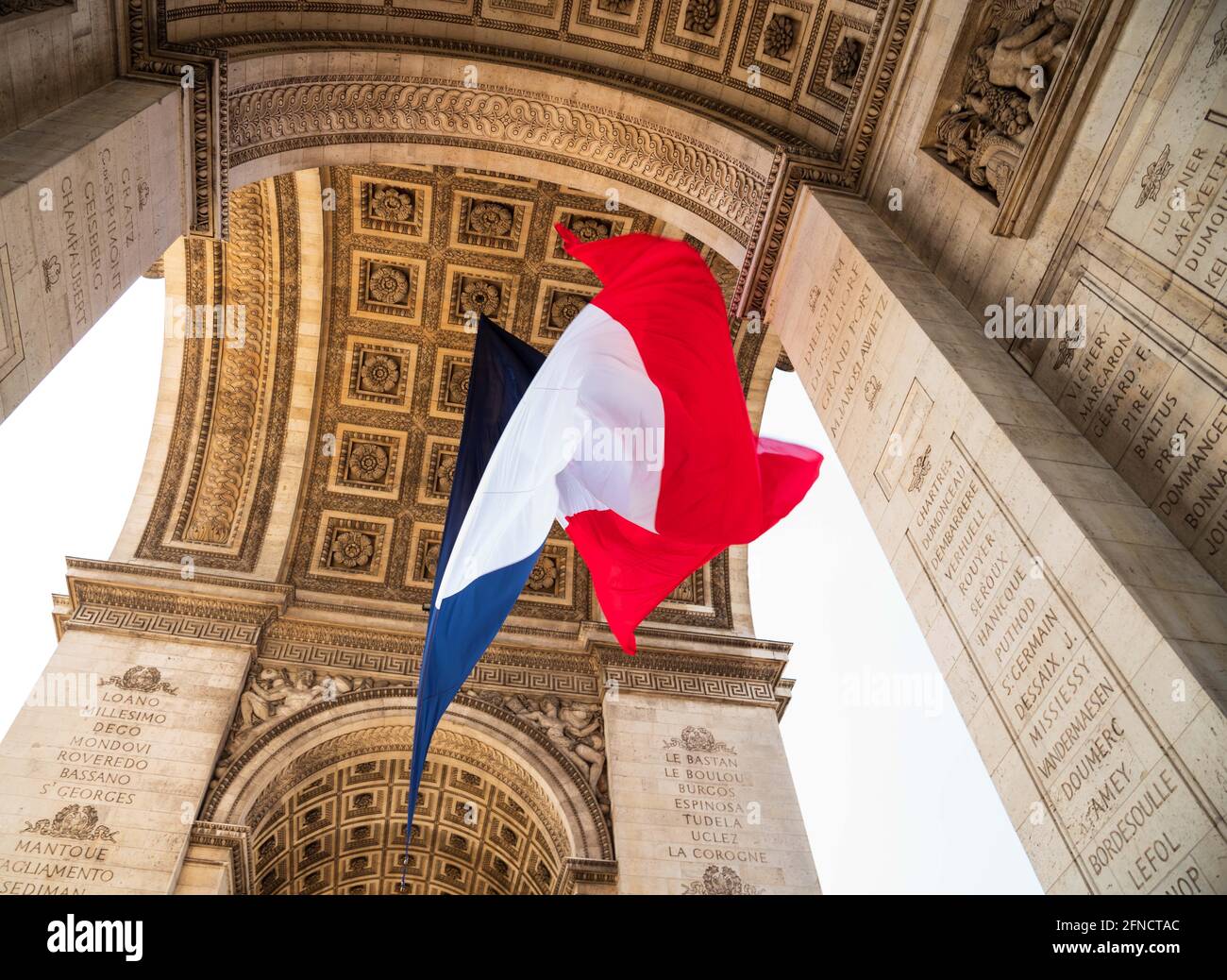 French flag waving under Arc de Triomphe in honor of VE day. Paris ...