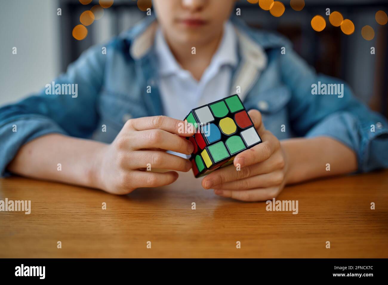 Boy trying to solve puzzle cube, focus on hands Stock Photo - Alamy