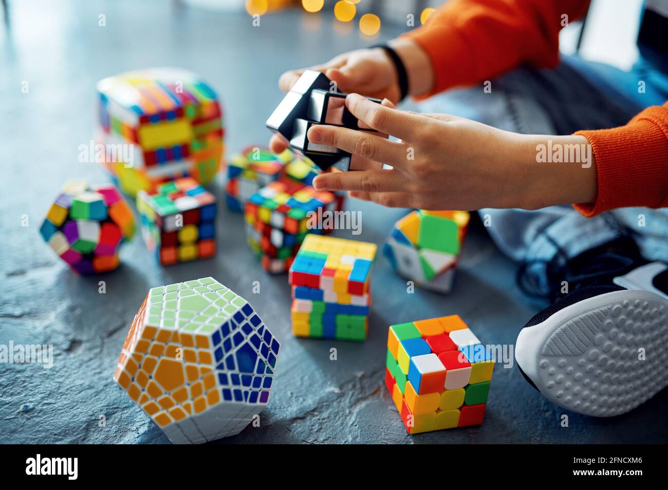 Male child trying to solve different puzzle cubes Stock Photo - Alamy