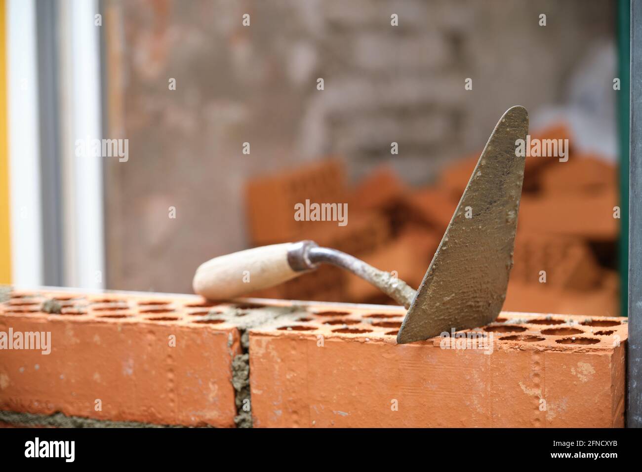 Construction trowel on a brick wall. Construction site concept Stock ...
