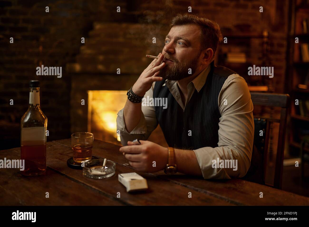Man smokes cigarette and drinks alcohol beverage Stock Photo - Alamy