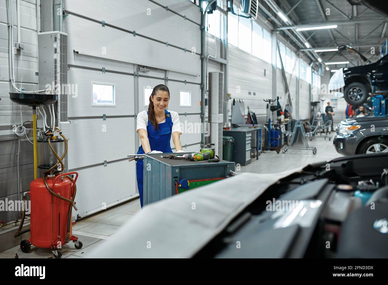 Female mechanic stands at the hood, car service Stock Photo - Alamy