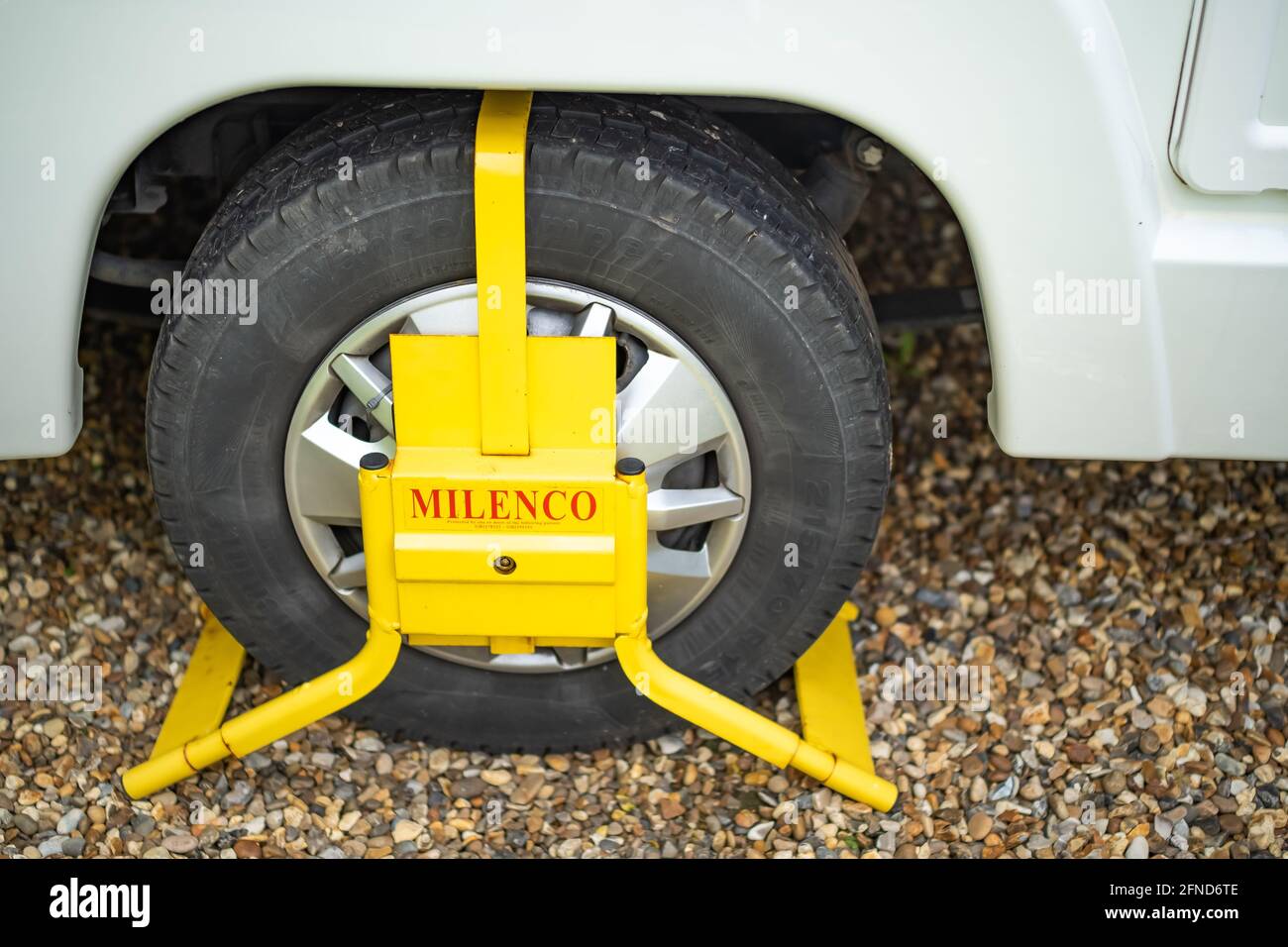 Heavy duty Milenco branded wheel clamp on the rear wheel of a coach ...