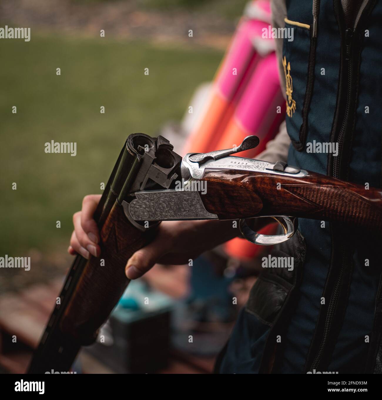 Man holding a break open double barreled shotgun. Shooting clay disks ...