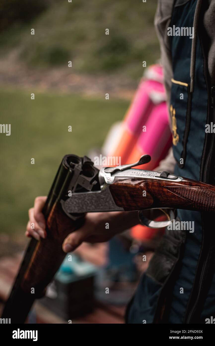 Man holding a break open double barreled shotgun. Shooting clay disks ...