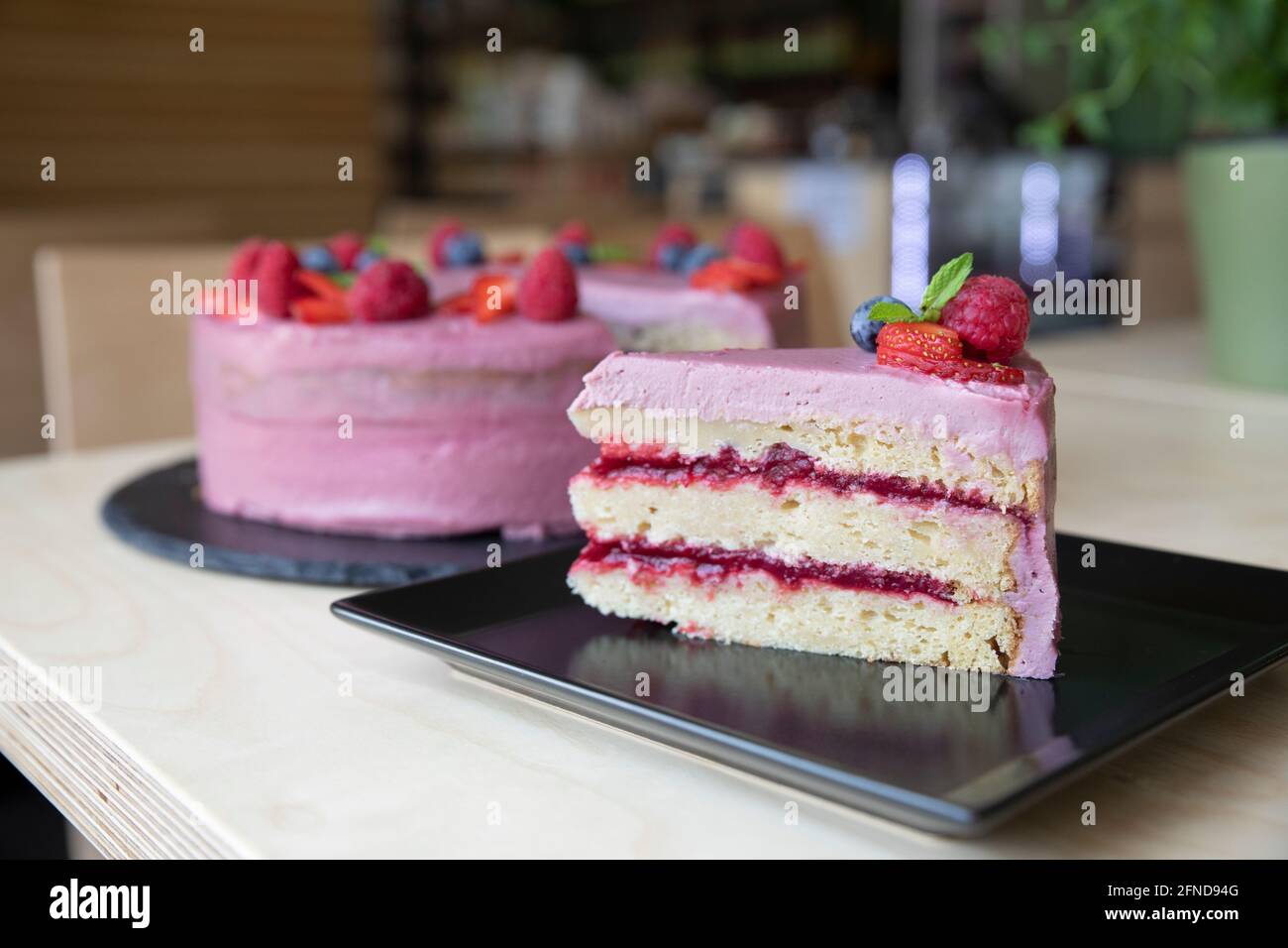 Ruby chocolate cake with raspberries in a cafe Stock Photo - Alamy