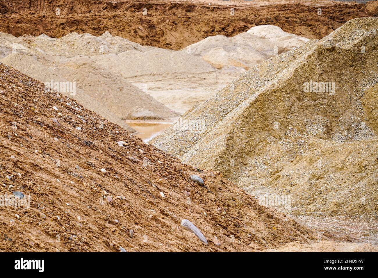 view of a gravel and pebble quarry with piles of materials of different ...