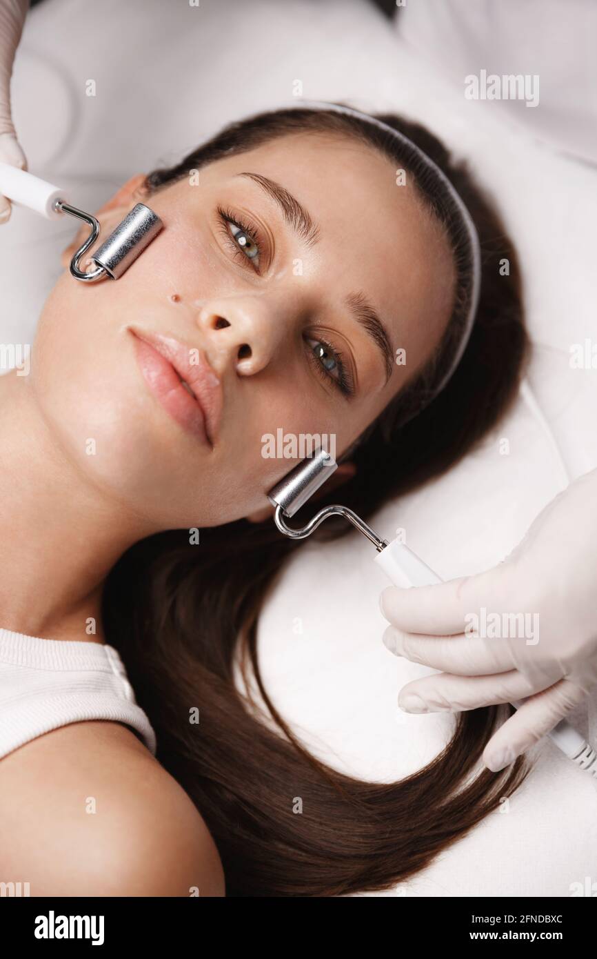 Woman beauty face with galvanic gel, female patient receives galvanic ...