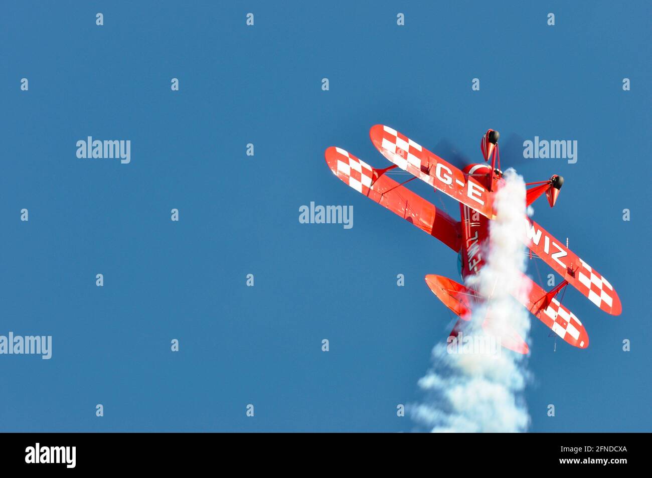 Pitts Special aerobatic plane climbing steeply into a bright blue sky ...