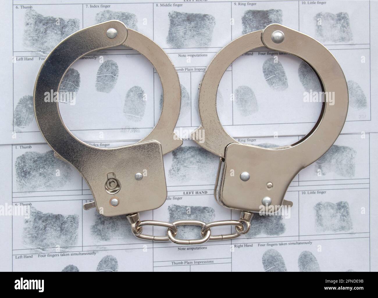 Top view of metal Handcuffs with generic hand prints Stock Photo - Alamy