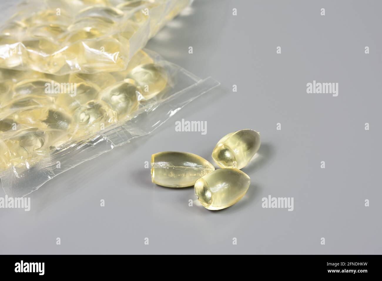 Sachets of glycerin suppositories, and three suppositories, on a gray ...