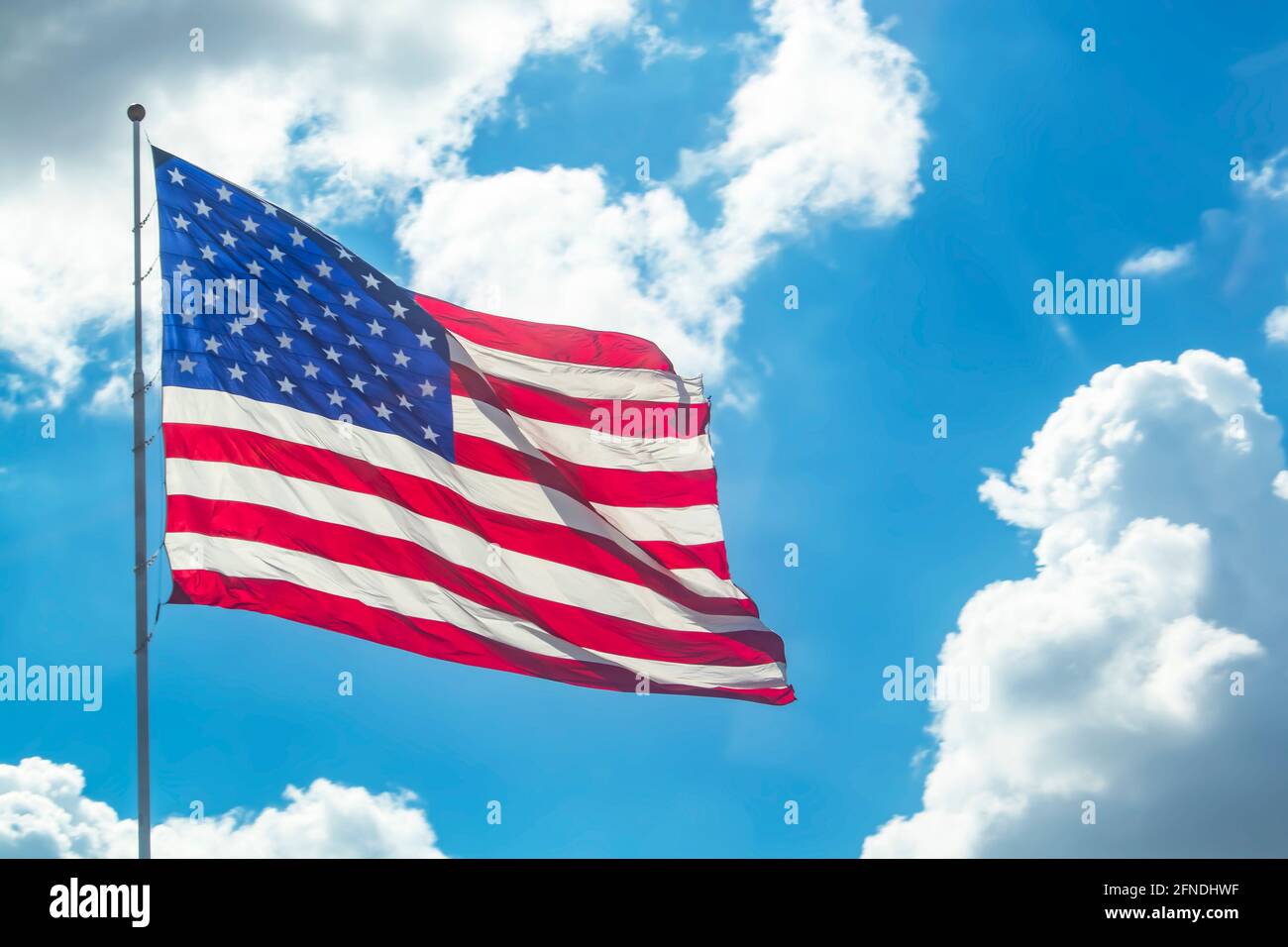 American flag blue sky fluffy white clouds hi-res stock photography and ...